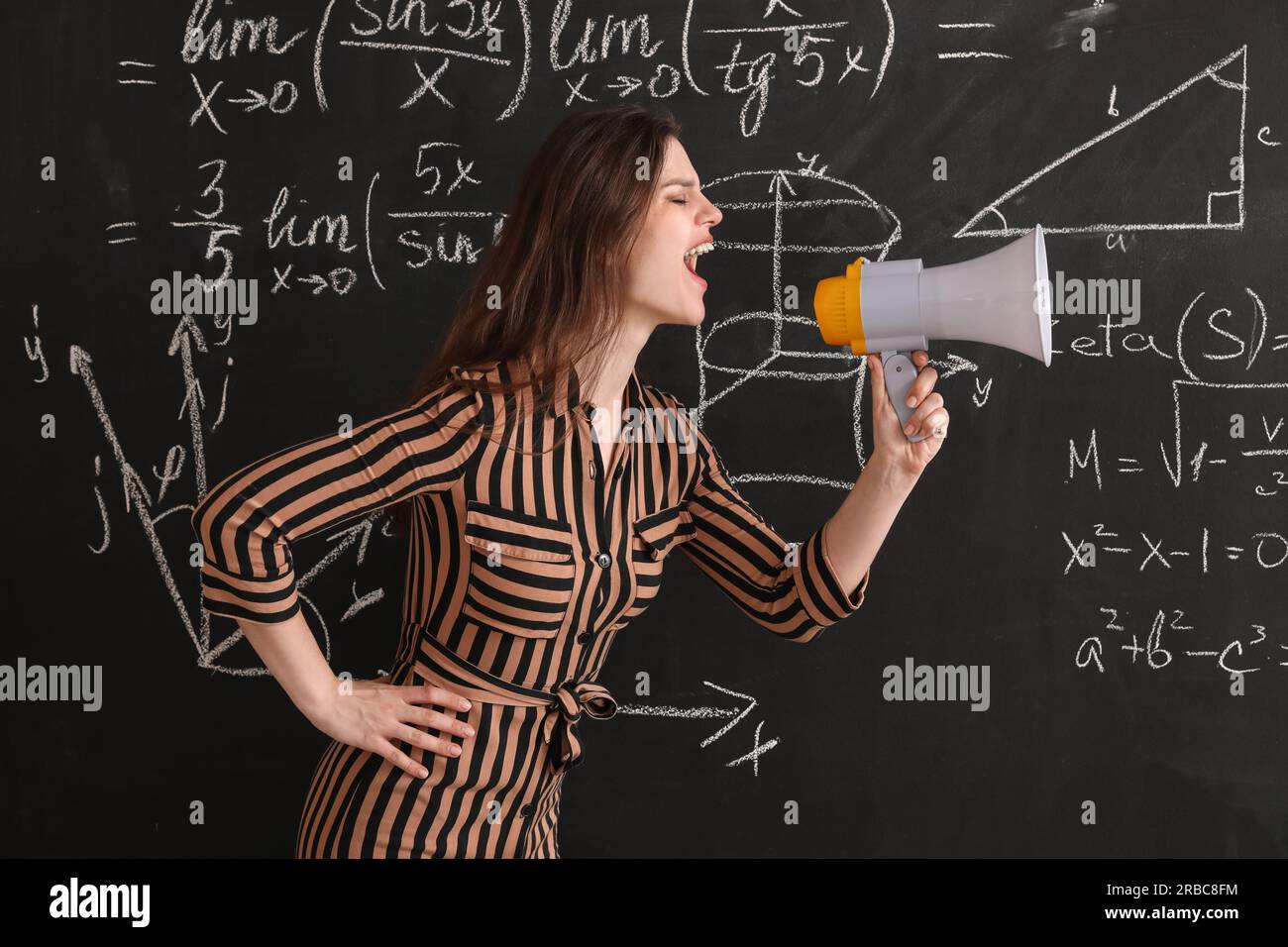 Female Math teacher shouting into megaphone near blackboard in ...