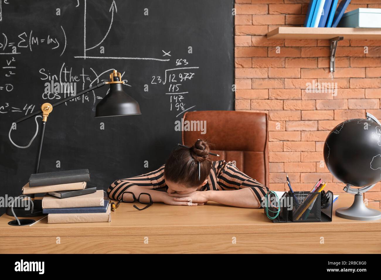 Female teacher sleeping at table in classroom Stock Photo - Alamy