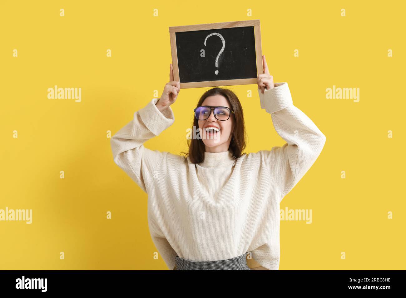 Female teacher holding chalkboard with question mark on yellow ...