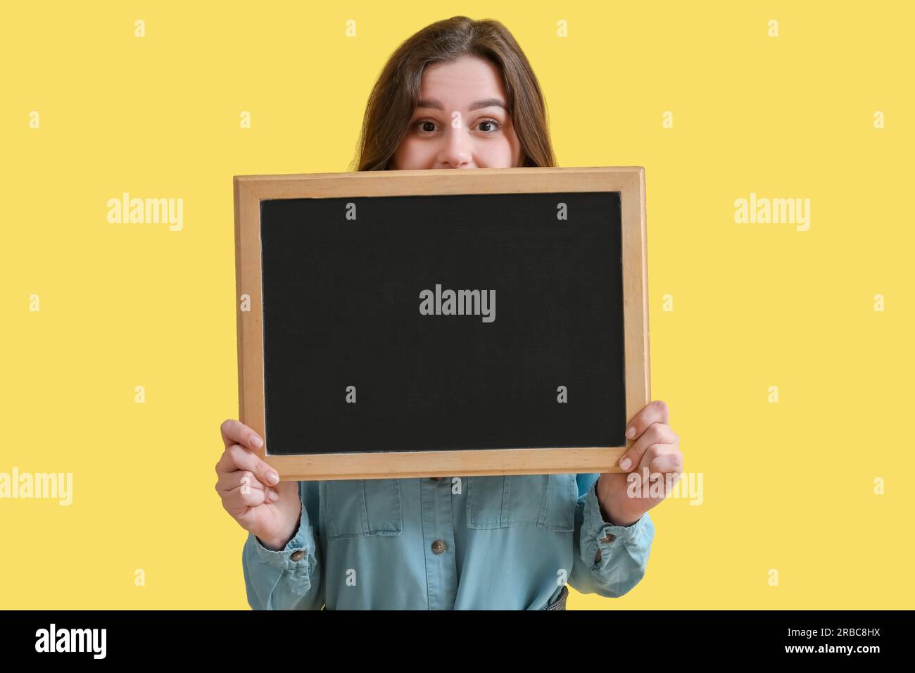 Female teacher with chalkboard on yellow background Stock Photo - Alamy