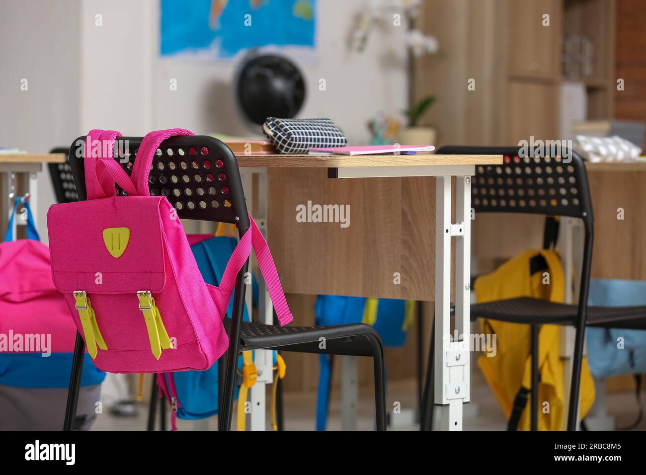 Chair with backpack in classroom Stock Photo - Alamy