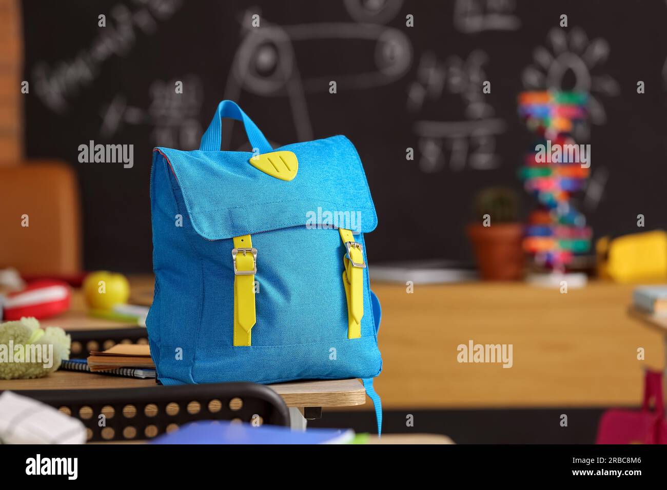 Backpack on desk in classroom Stock Photo - Alamy