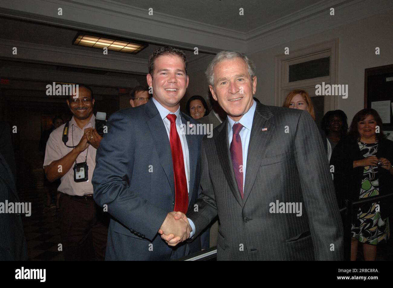 Department staff greeting President George W. Bush, from behind rope ...