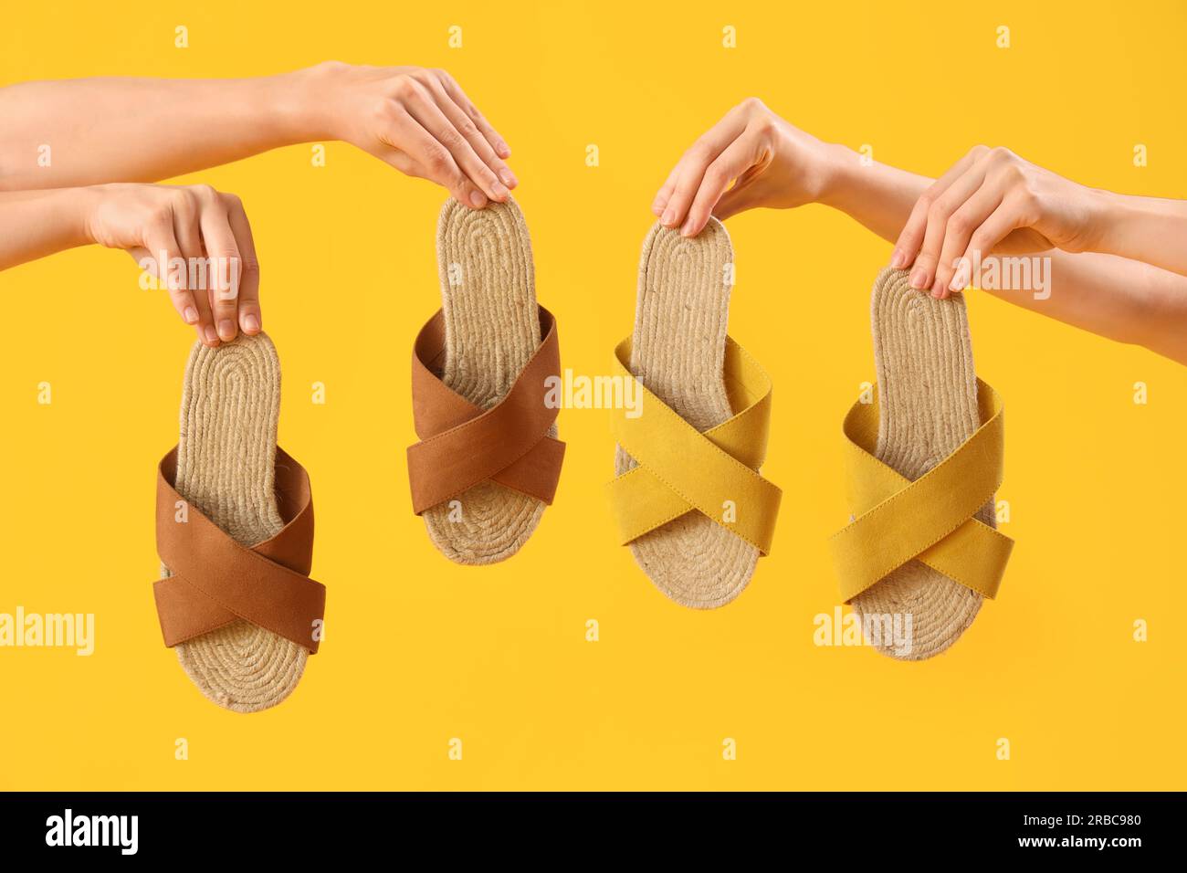 Hands with flip-flops on yellow background Stock Photo - Alamy