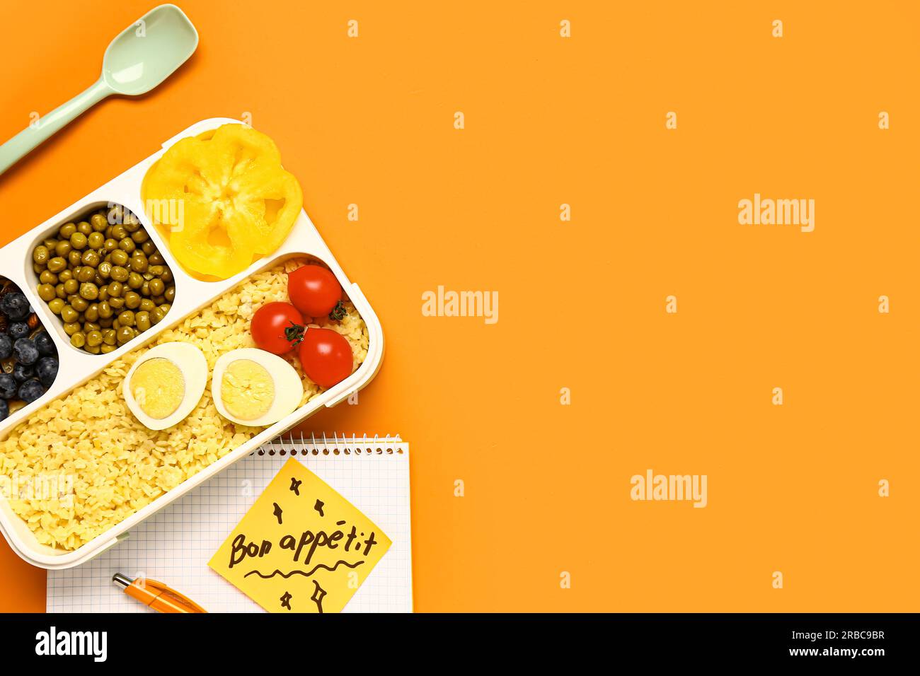 Stationery, tasty food in lunchbox and sticky note with text BON ...