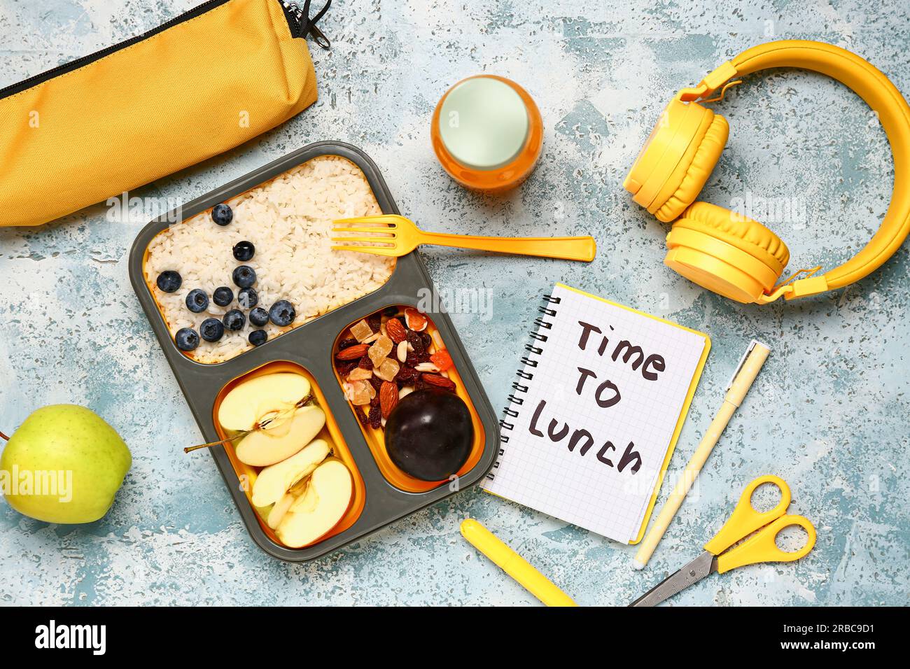 Stationery, tasty food in lunchbox and notebook with text TIME TO LUNCH ...