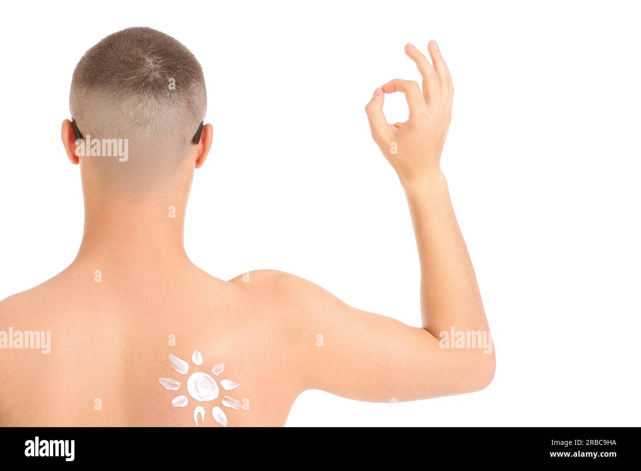 Young man with sun made of protection cream on his body showing OK ...