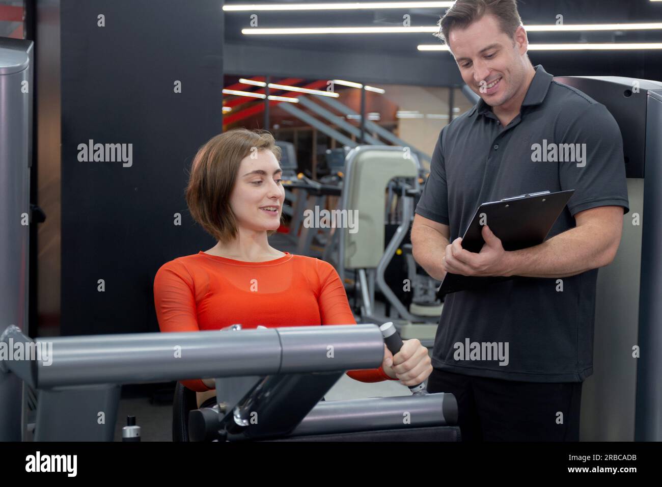 Coach man guidance workout with legs muscles stretch with equipment ...