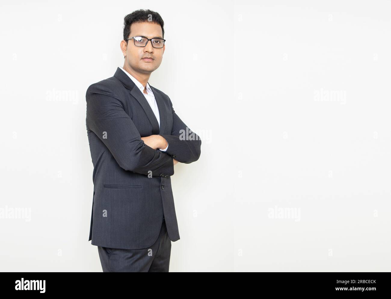 Young indian businessman wearing suit standing cross arms isolated over ...