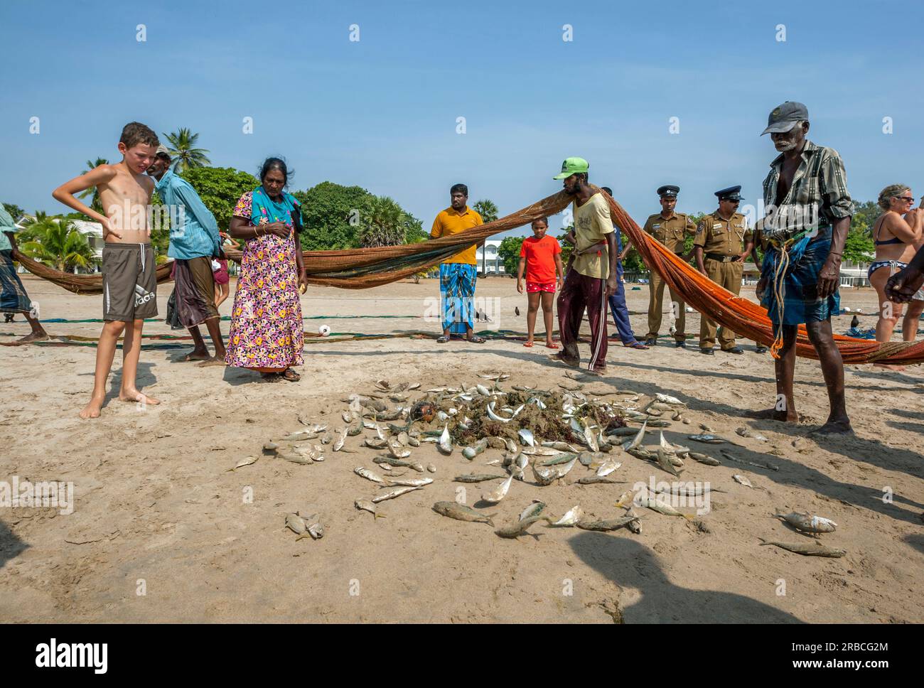 People gather on Uppuveli beach in Sri Lanka to inspect the poor fish ...