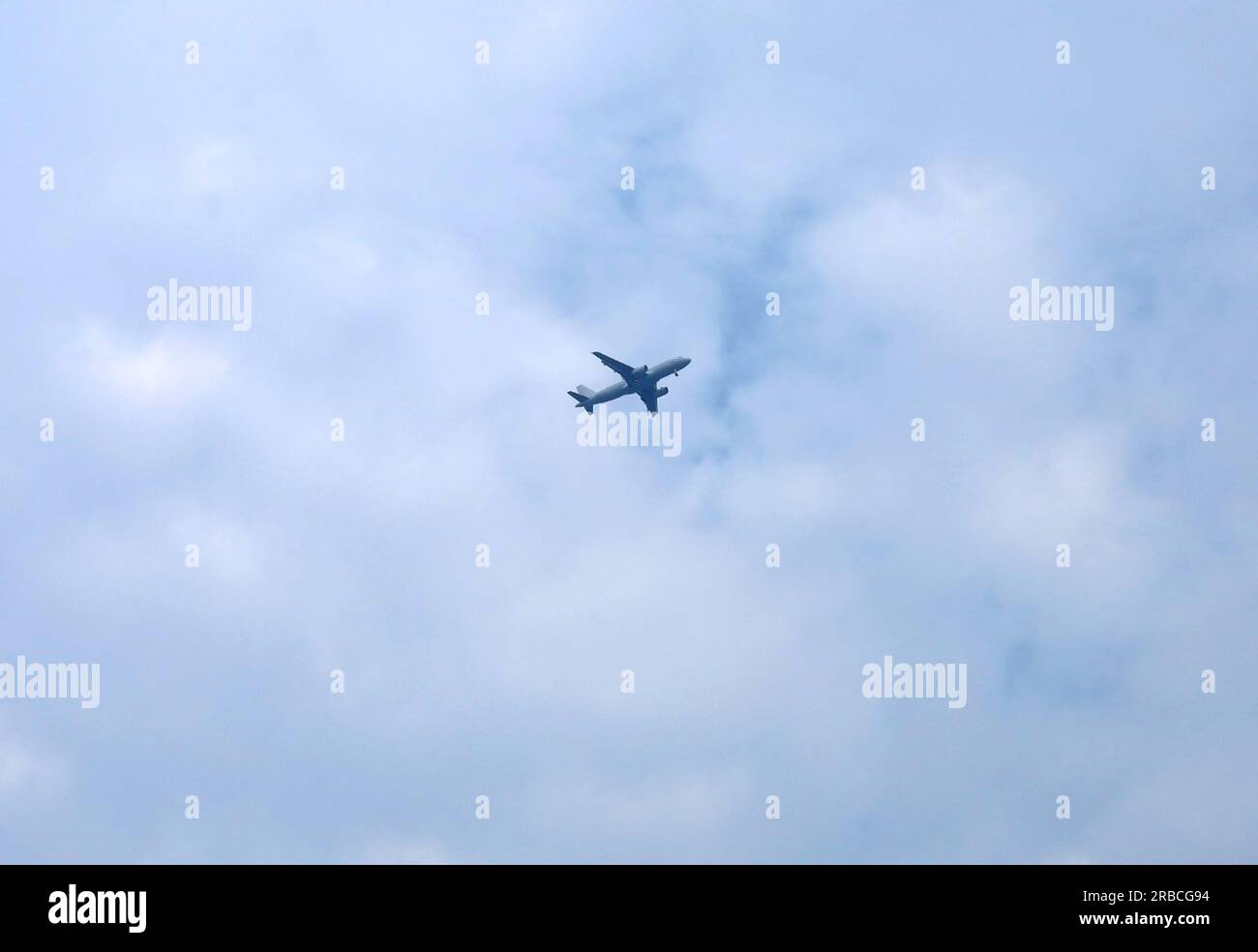 A plane flying overhead over the clouds at the sky Stock Photo - Alamy