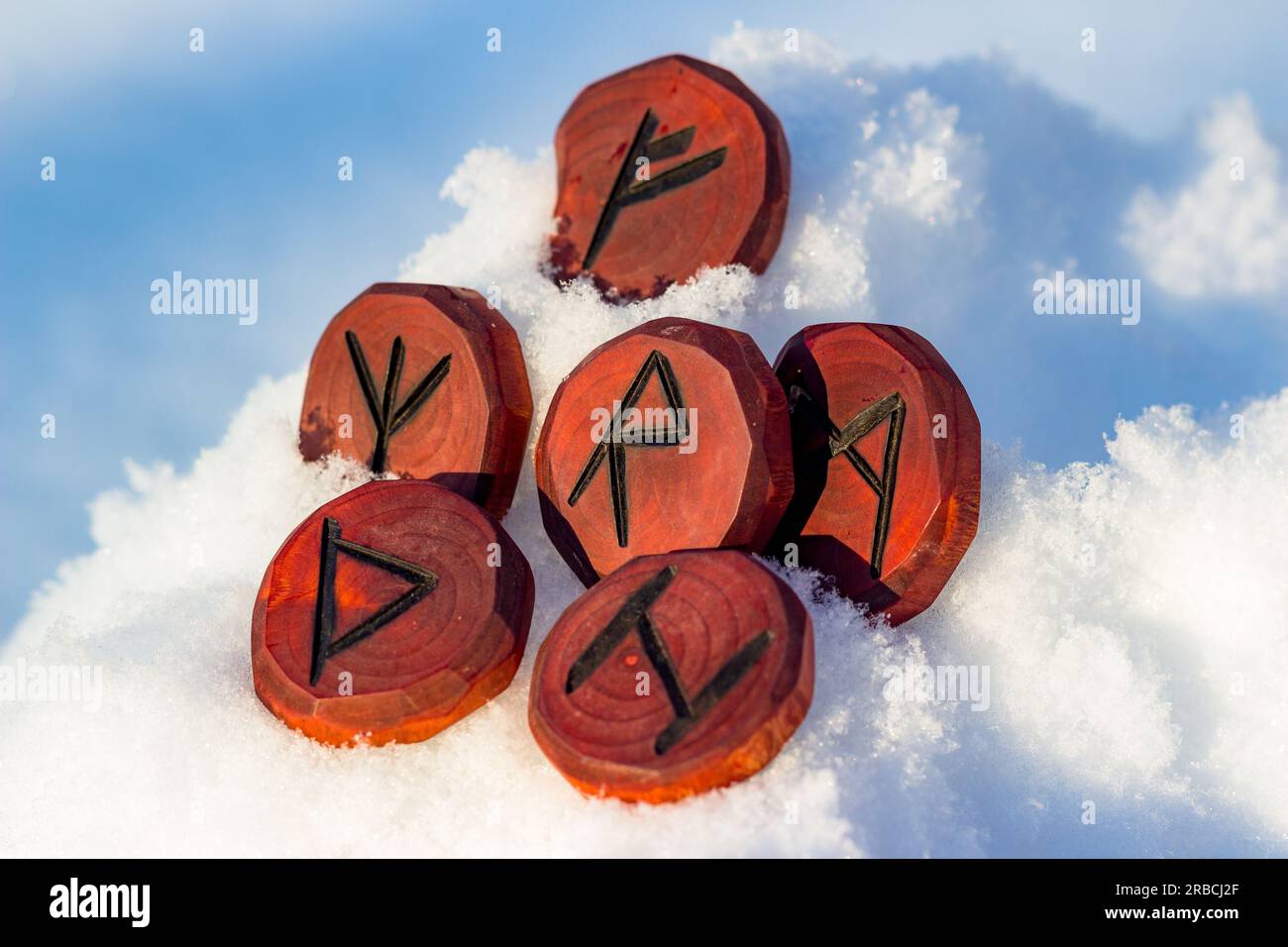 Elder Futhark. Runes of red color carved from wood in the snow Stock ...