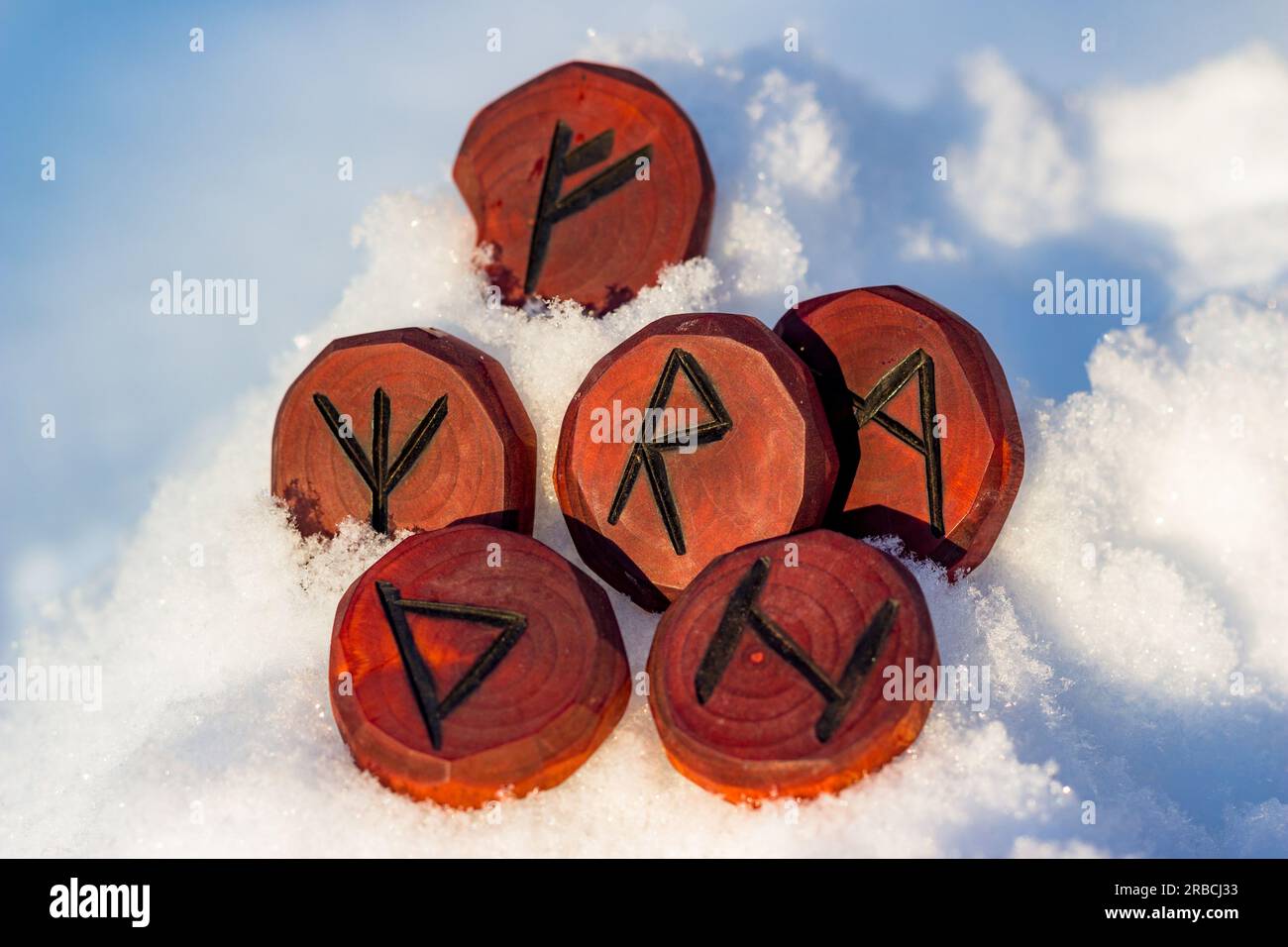 Runes of red color carved from wood in the snow - Elder Futhark Stock ...