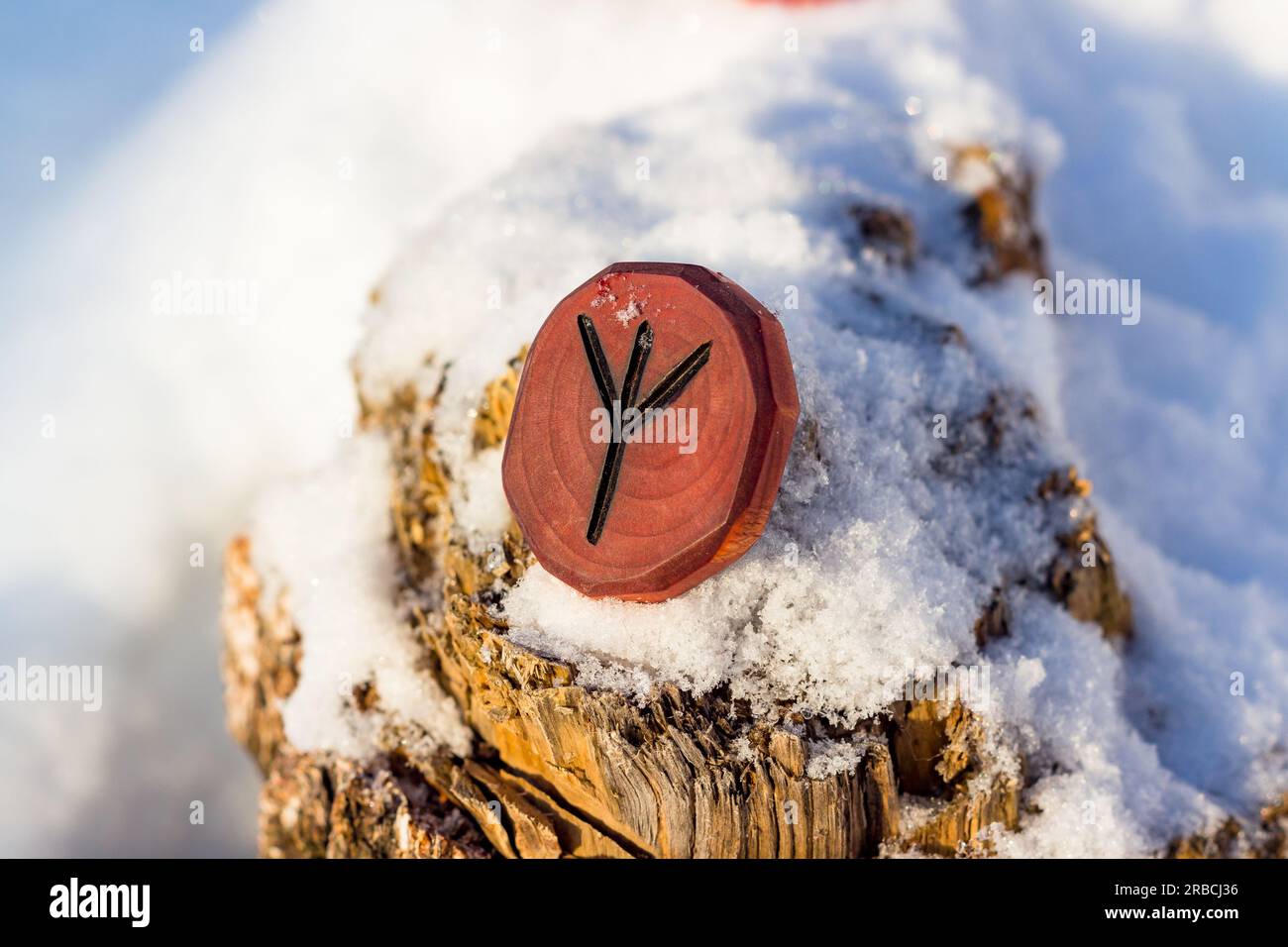 Rune inverted Algiz (Elhaz) carved from wood in the snow Stock Photo ...