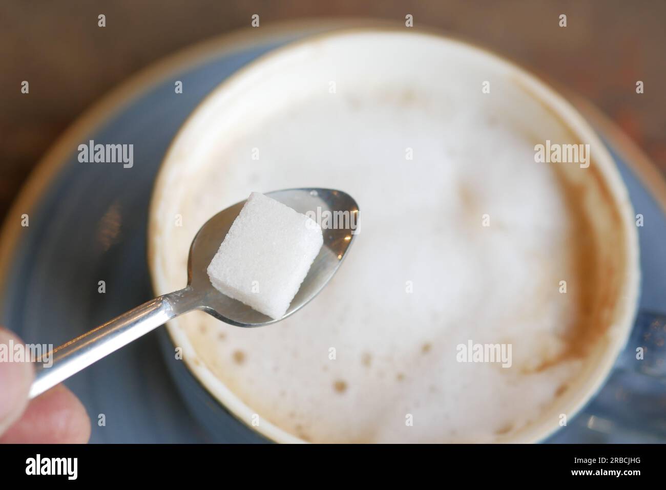 pouring white sugar cube in a coffee cup Stock Photo - Alamy