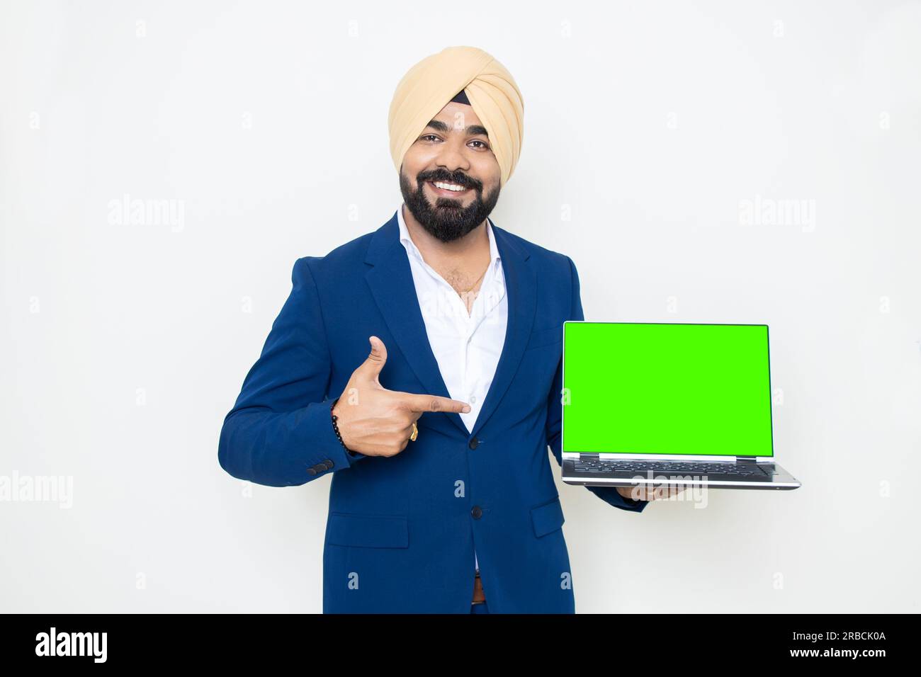 Happy young indian sikh businessman wearing blue suit and turban ...