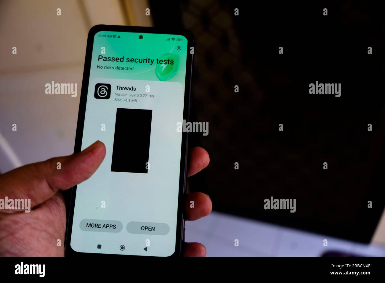 a hand holding a smatphone displaying Thread Application of Instagram ...