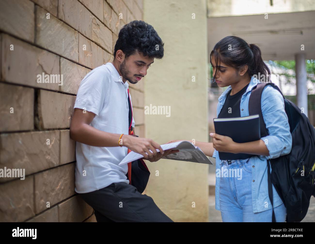 Two young Students reading books in the college campus Stock Photo - Alamy
