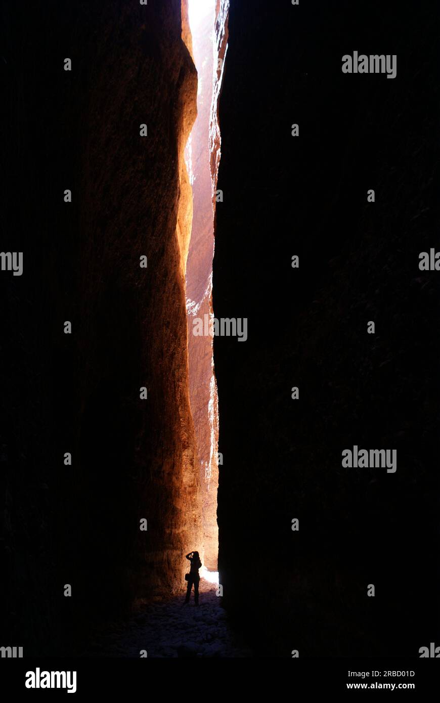 Person standing in the sunbeam shining into the narrow cleft between ...