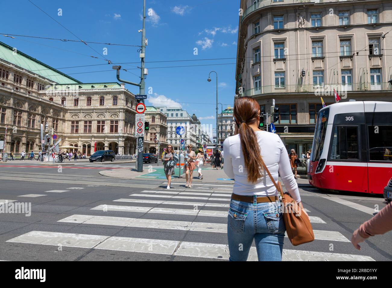 VIENNA, AUSTRIA - JUNE 13, 2023: People cross the street at a ...