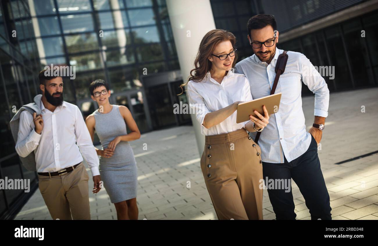 Group of business people walking outside in front of office buildings ...