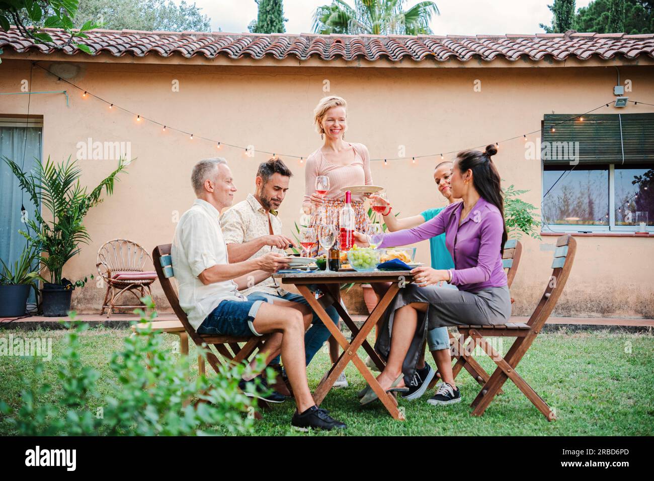 A group of mature adult friends having fun together on a barbeque lunch ...