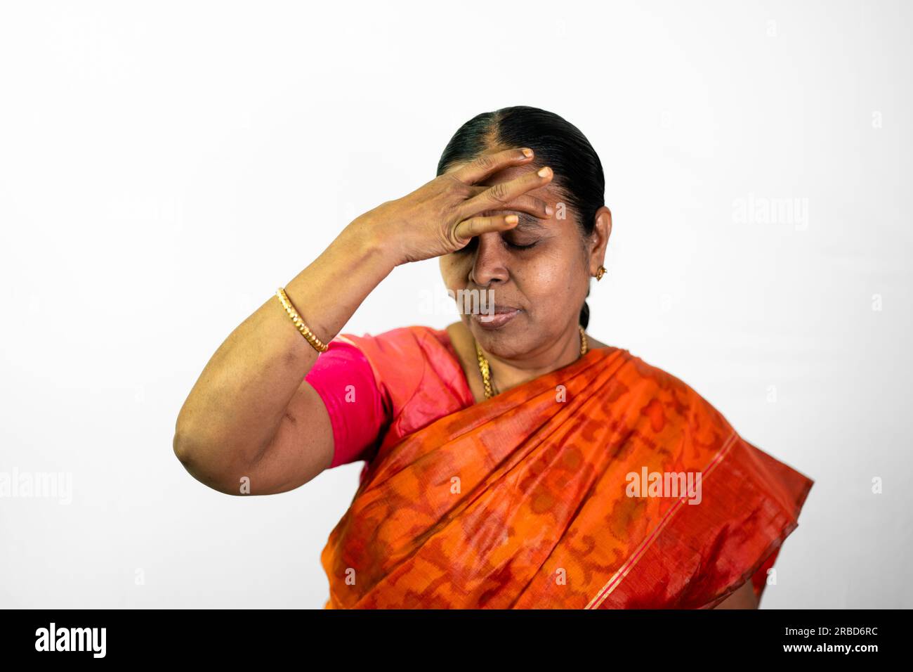 A close-up portrait of a South Indian woman in her 20s making a ...