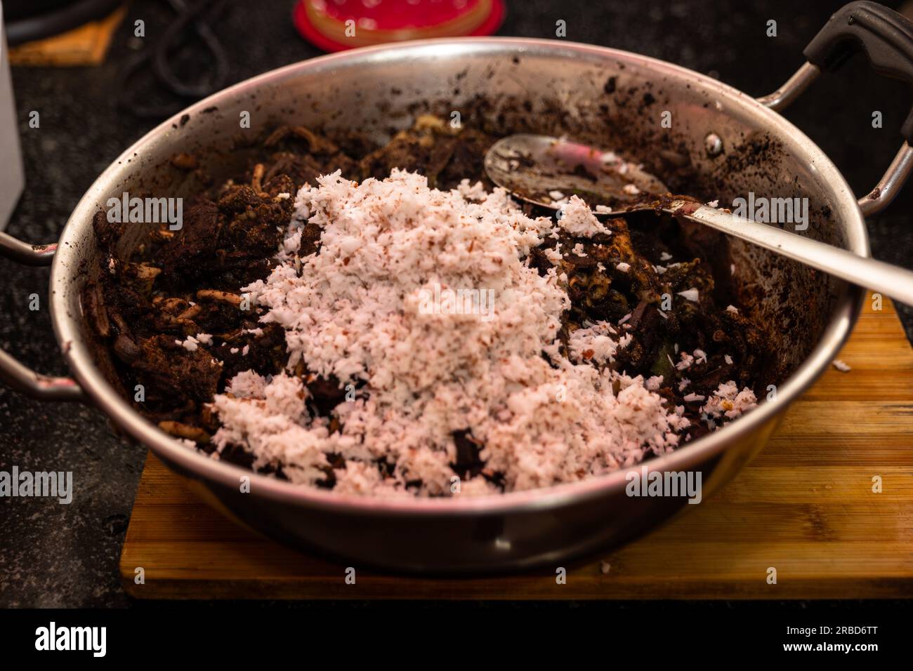 A close-up photo of mutton meat and blood being fried in a pan with ...