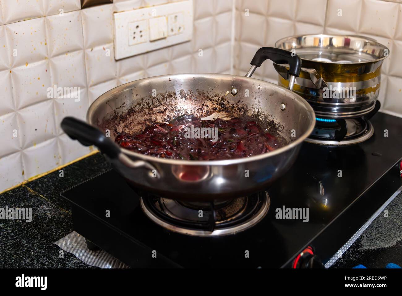 A close-up photo of mutton meat and blood being fried in a pan. The ...