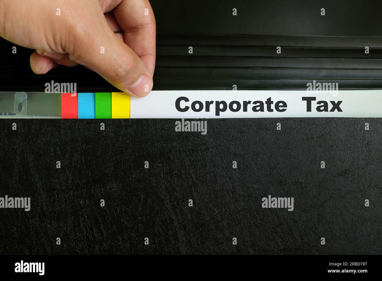 Hand picking corporate tax file record in black binder folder. Business ...