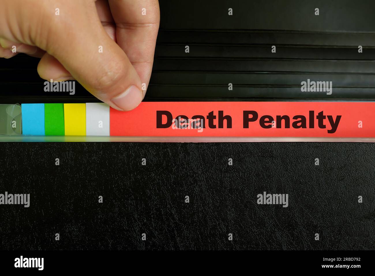 Hand picking death penalty file record in black binder folder. Law and ...
