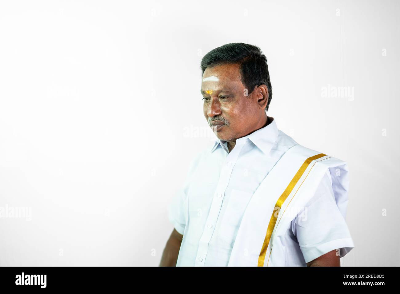 A south Indian man in his 50s, wearing a white dress shirt and a ...