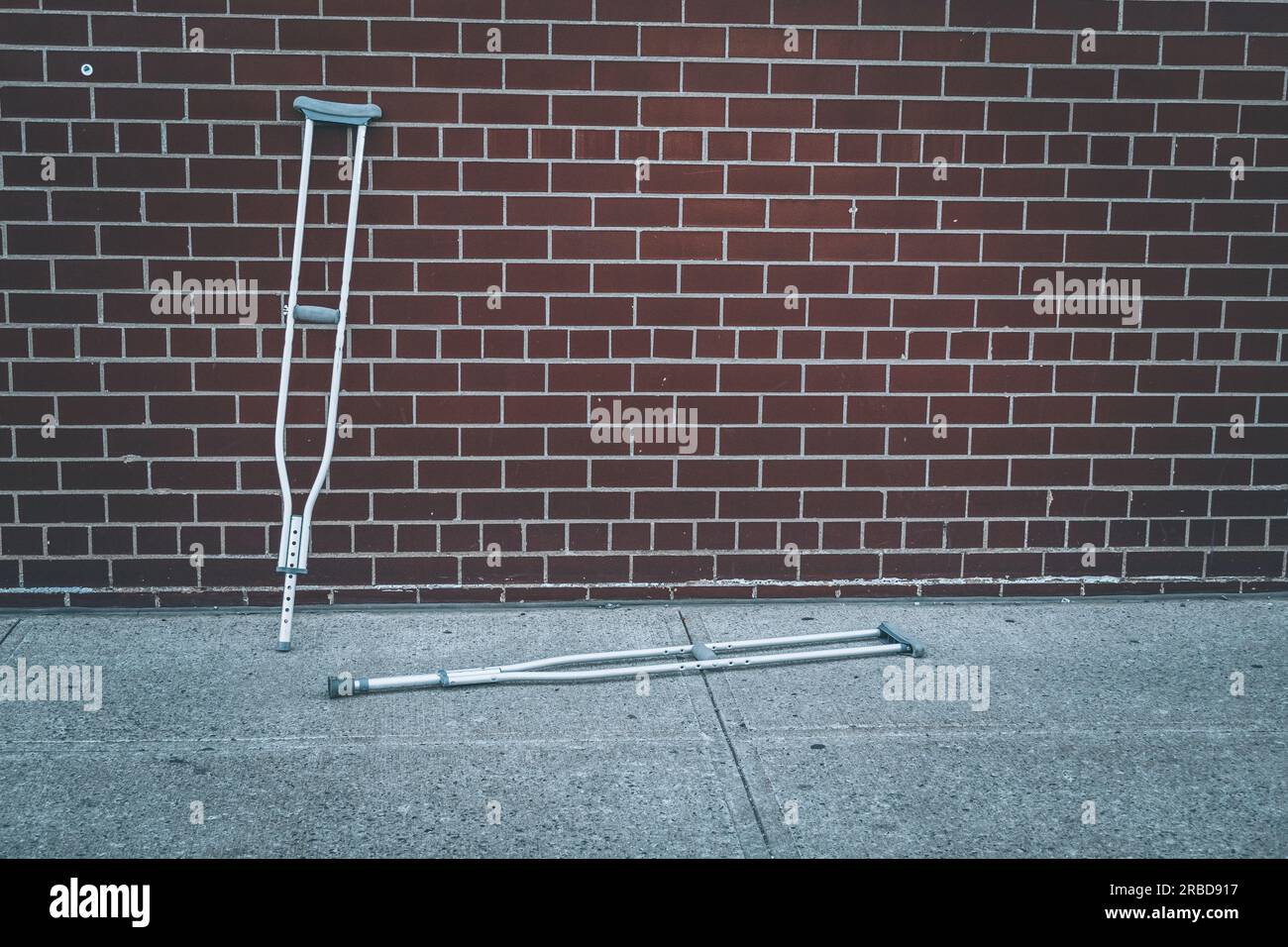 Pair of crutches ababdoned by a brick wall, New York Stock Photo - Alamy