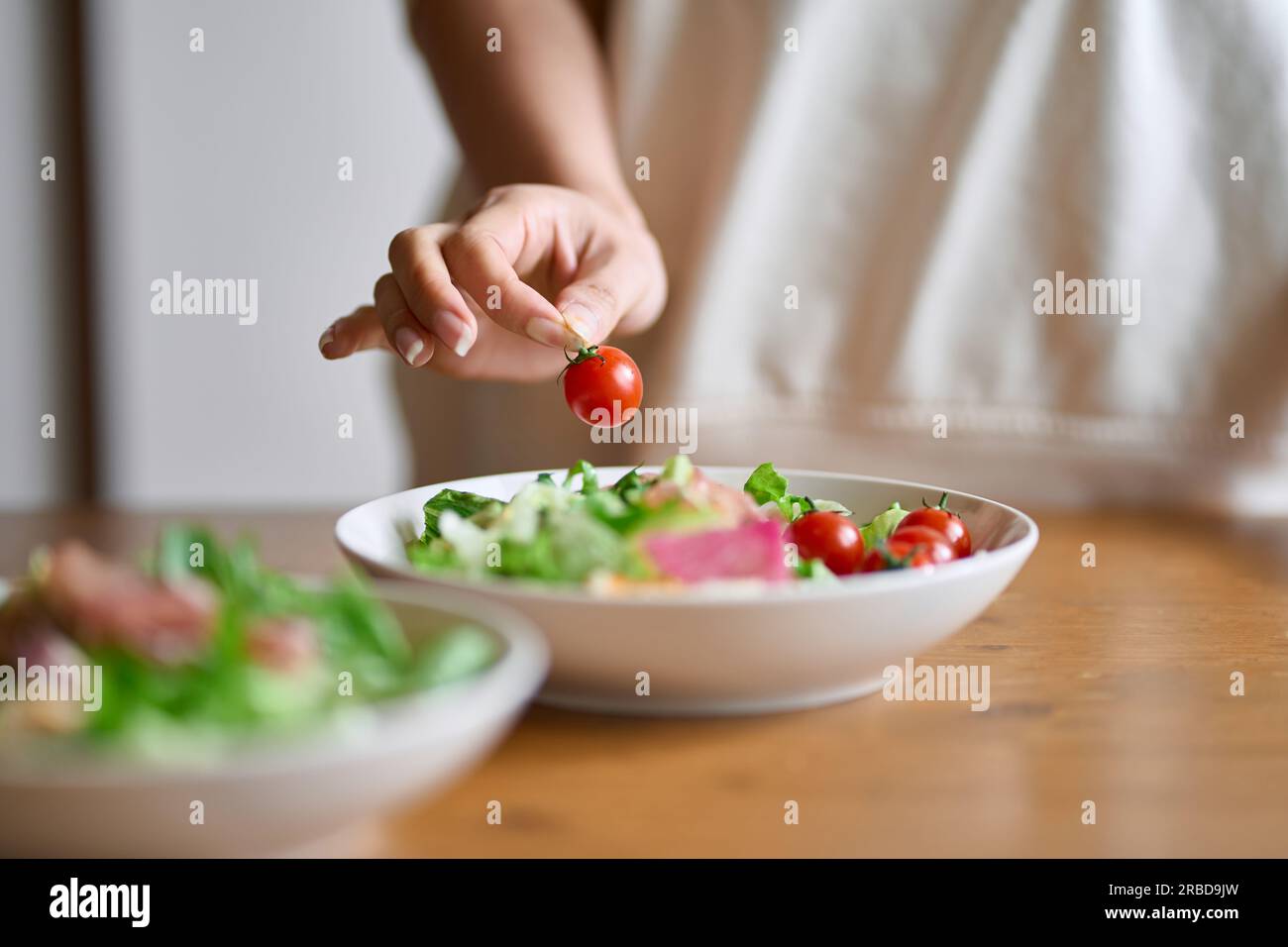 A woman's hand serving a salad Stock Photo - Alamy