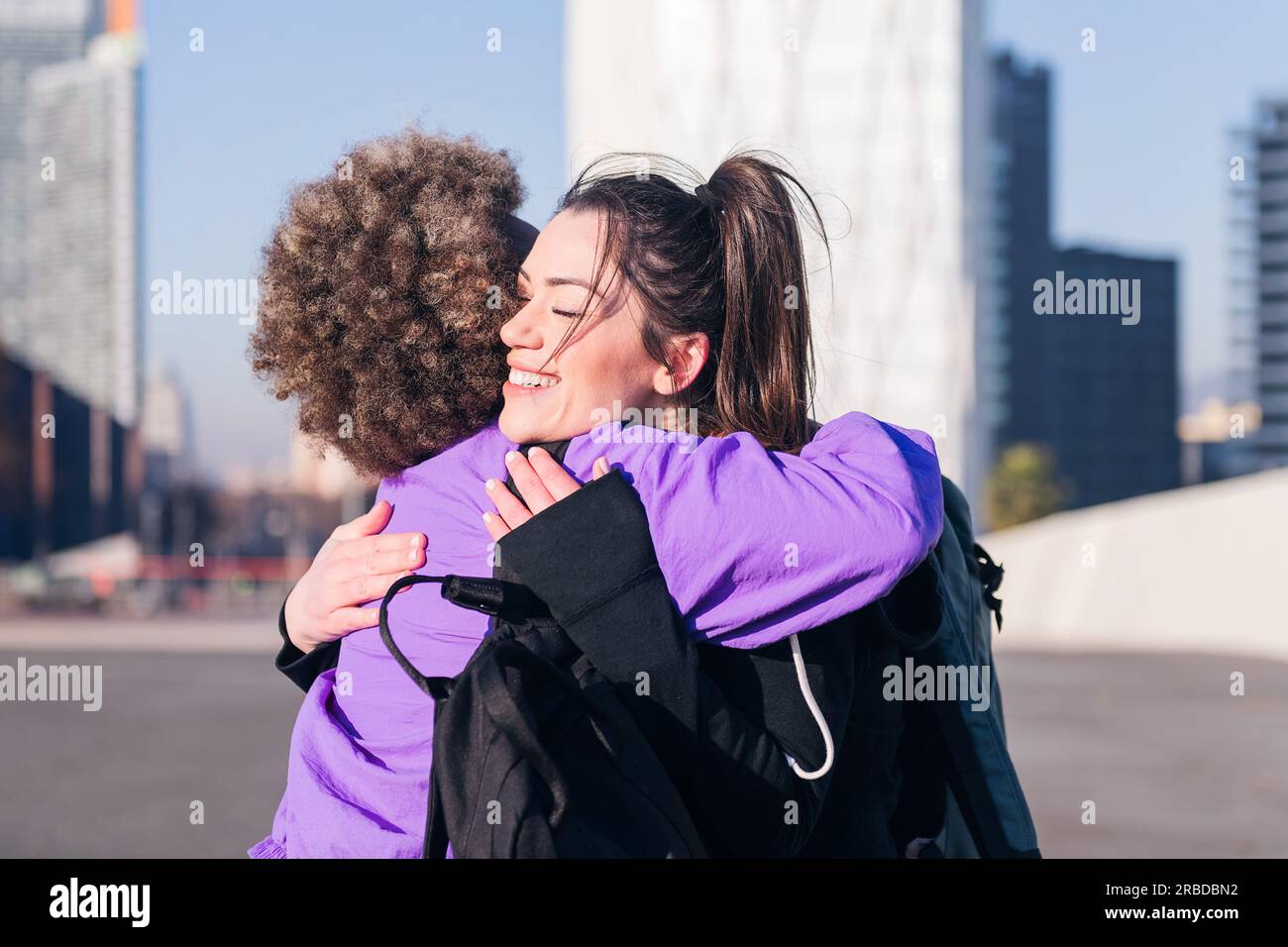 two friends embracing before running in the city Stock Photo - Alamy