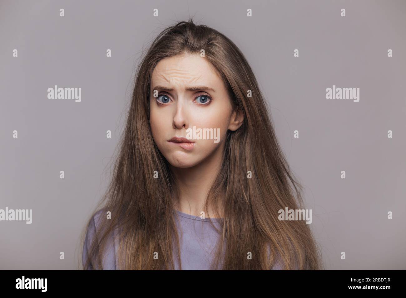 Stressed female bites lip, shows dissatisfaction. Sorrorful expression ...