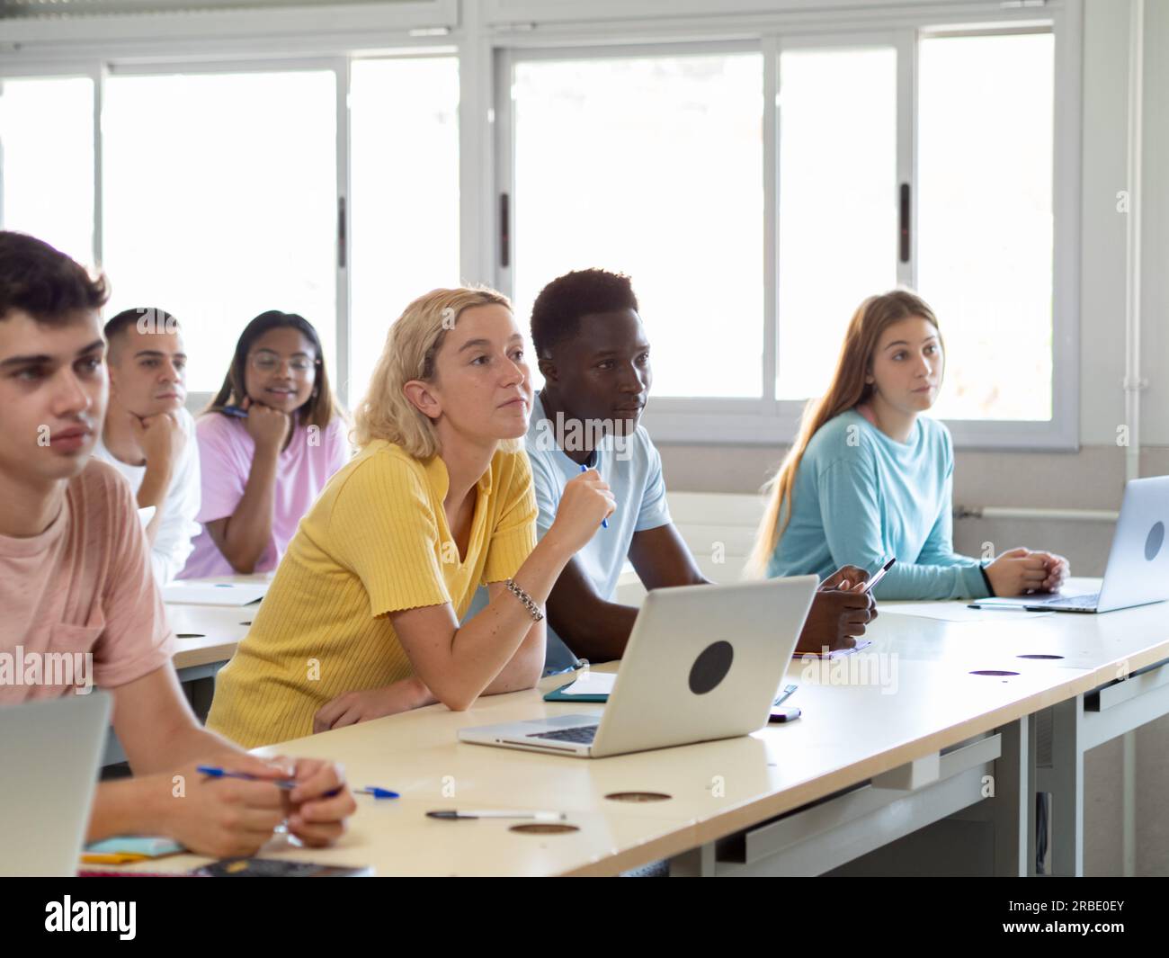 Group of diverse teen students in class listening to the lesson. High ...