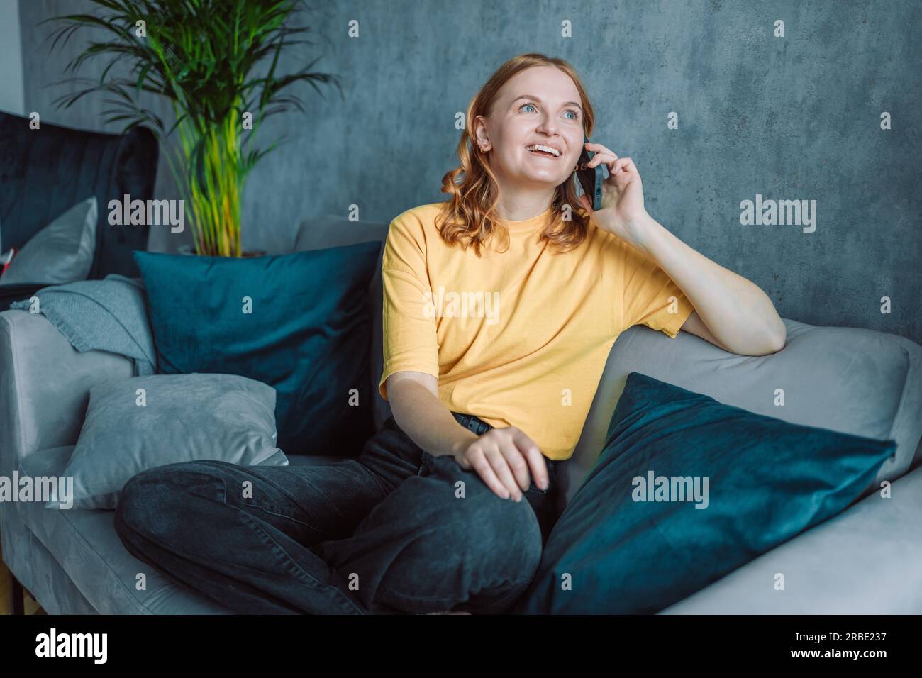 Happy cheerful young woman talking on the phone at home, smiling teen ...