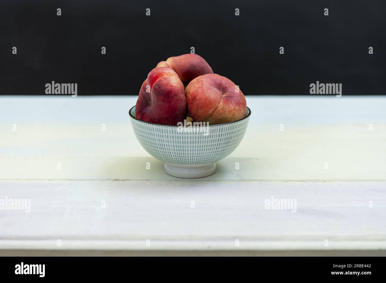 A small blue bowl with a few paraguayas inside Stock Photo - Alamy
