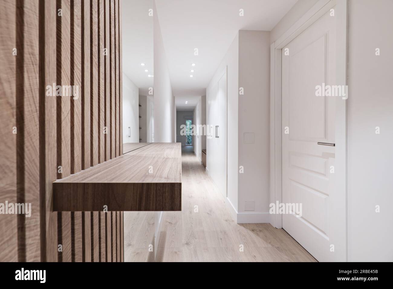 corridor of a house with white wooden access doors and a wooden ...