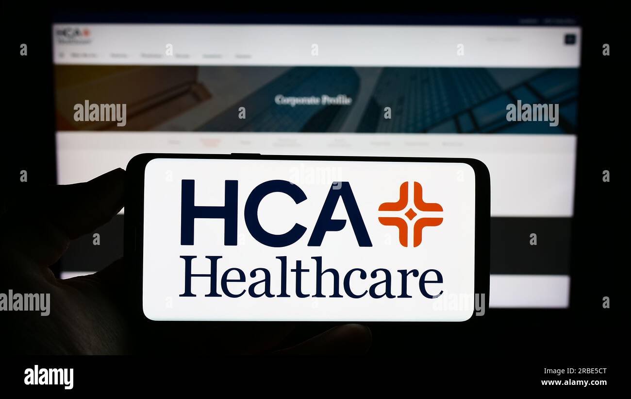 Person holding smartphone with logo of US company HCA Healthcare Inc ...