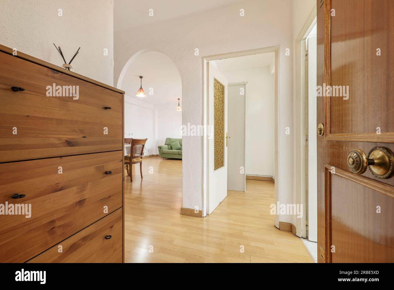 Entrance hall of an empty house with wooden floors, a wooden sideboard ...