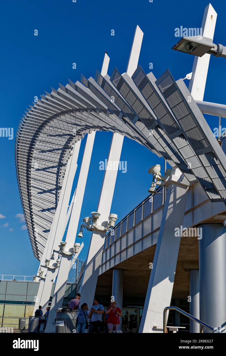 Brilliant white against a blue sky, a steel-panel arch soars above the ...
