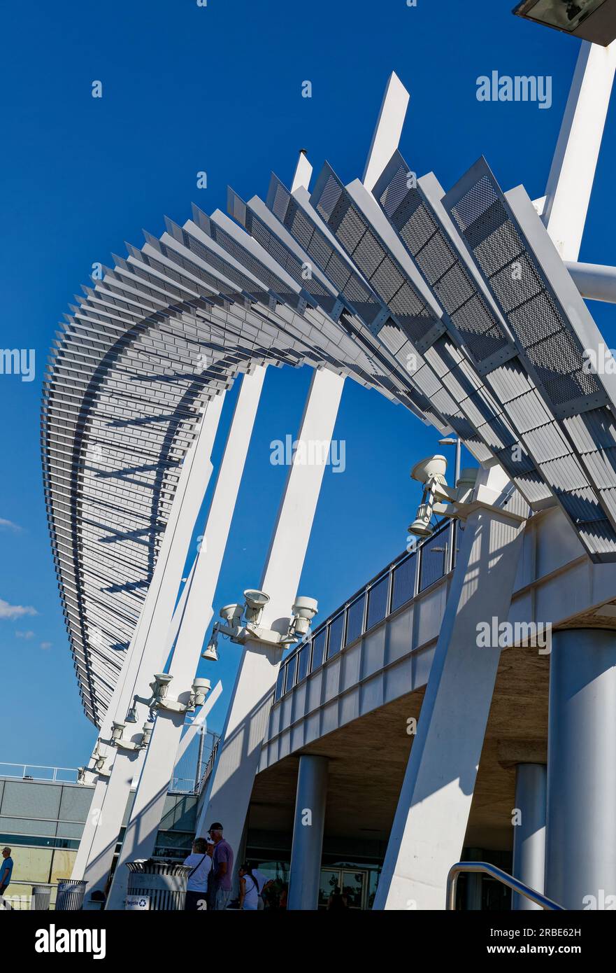 Brilliant white against a blue sky, a steel-panel arch soars above the ...