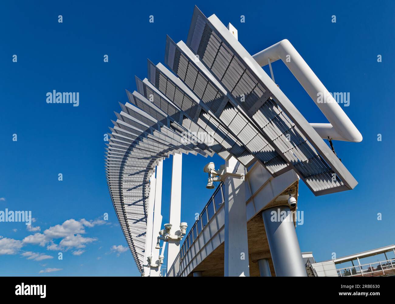 Brilliant white against a blue sky, a steel-panel arch soars above the ...