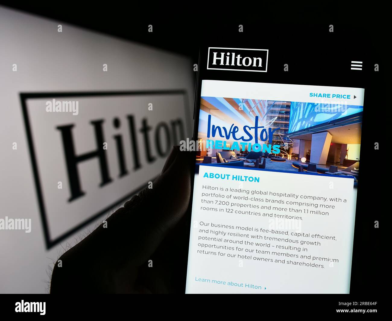 Person holding smartphone with website of US company Hilton Worldwide ...