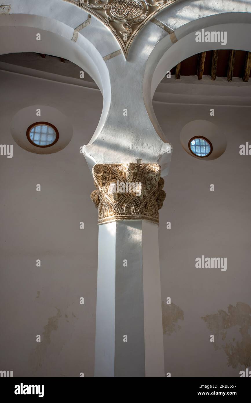 A pillar with a carved capital under some arches in a Hebrew temple ...