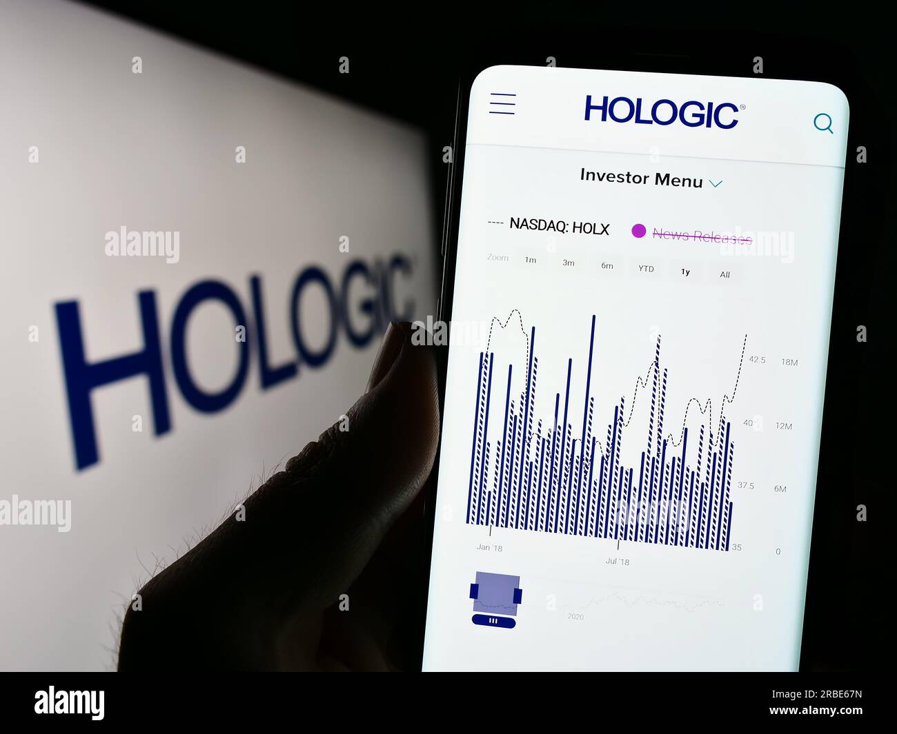 Person holding cellphone with website of US medical technology company ...