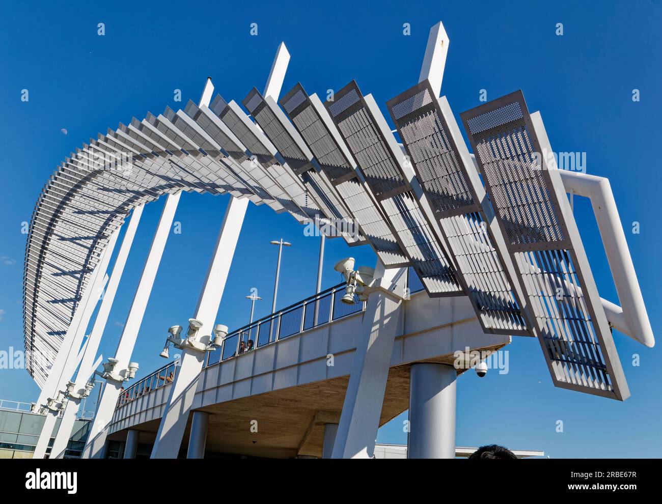 Brilliant white against a blue sky, a steel-panel arch soars above the ...