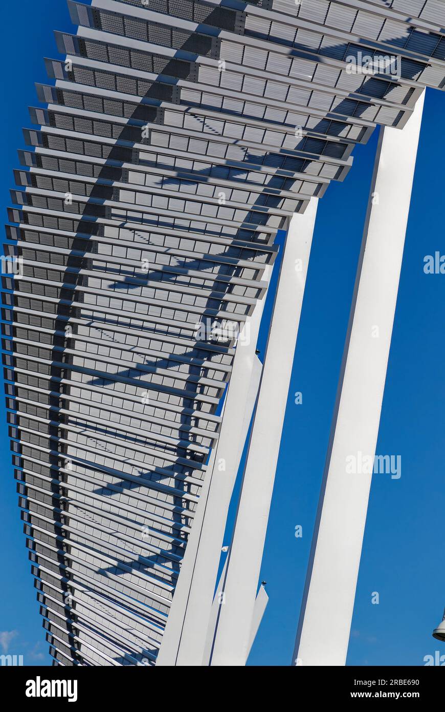 Brilliant white against a blue sky, a steel-panel arch soars above the ...